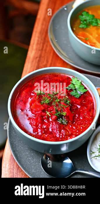 Red broth with dill garnish. Deep red broth with dill and parsley ...