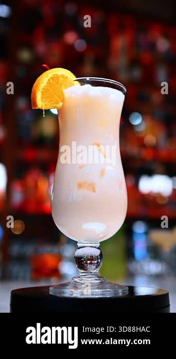 Creamy citrus cocktail glass. A creamy citrus drink with ice is served ...