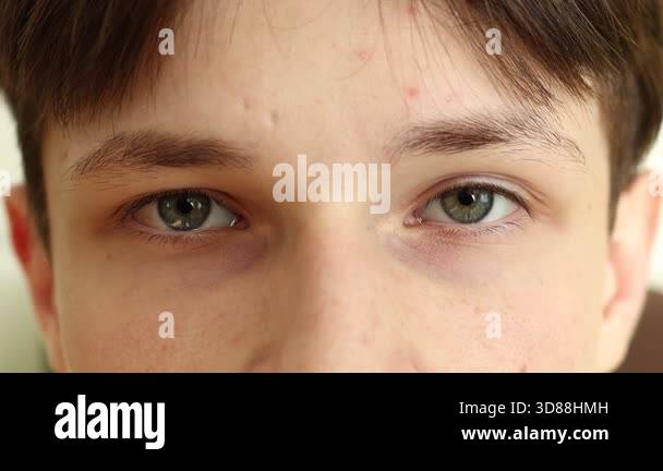 Blue eyes of teenager boy 15-17 years is looking at camera extreme ...