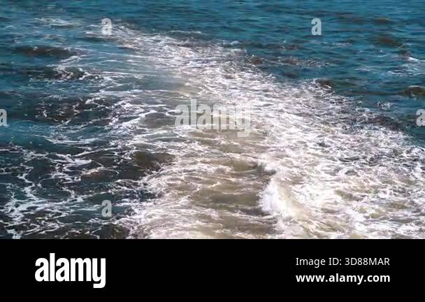 Ocean Waves Behind Moving Ferry. Churning ocean waves behind a moving ...