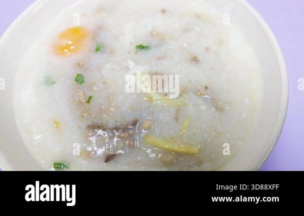 Rice porridge or congee with pork egg sliced ginger and vegetable ...