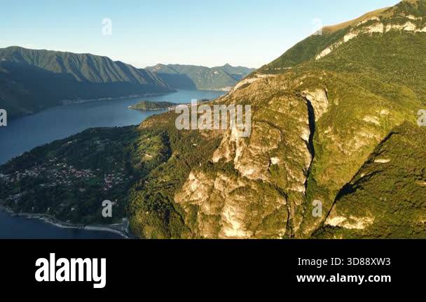 dramatic cliff overlooking deep fjord, aerial golden light reveals ...
