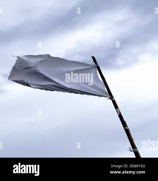 White Flag Waving Against Cloudy Sky. A white flag fluttered in the ...