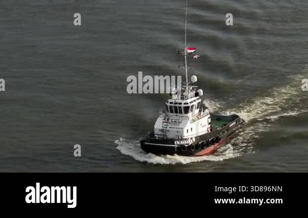 Dynamic, close-up aerial drone footage captures the small working tug ...