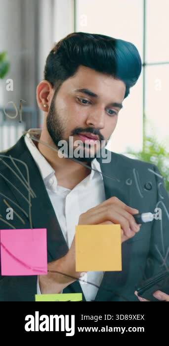 Likable positive high-skilled 30-aged bearded worker writing notes on ...