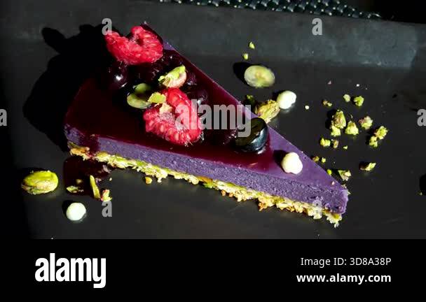 A piece of purple velvet cake with cream sprinkled with sugar served on ...