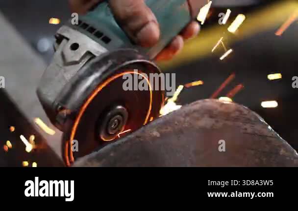 Close-up of an angle grinder cutting metal, producing a dramatic shower ...