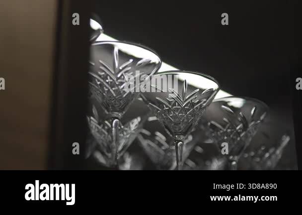 Crystal martini glasses stand in reflective row showing abstract ...