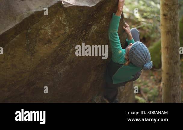 strong female climber climbs hard crag bouldering reaching holds on ...
