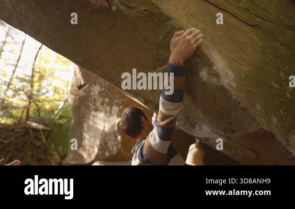 slow motion adult man rock climber climbs on overhanging cliff edges ...