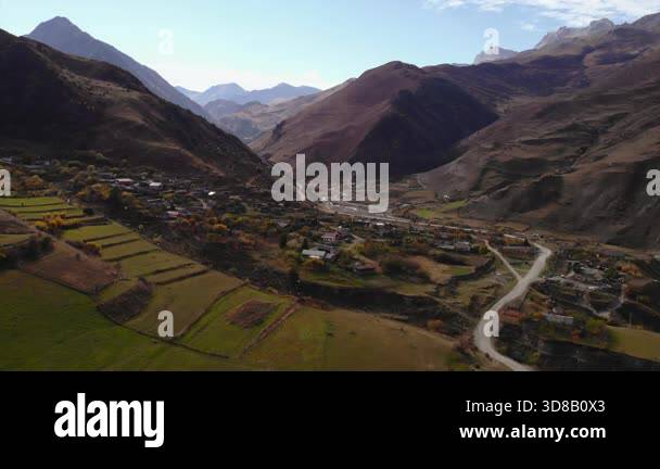 High angle drone footage showing a remote village nestled in a ...