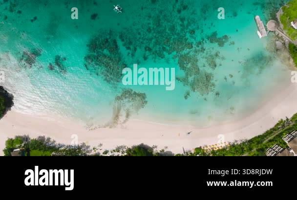 Boat over the clear turquoise sea water, waves on white sand with sun ...