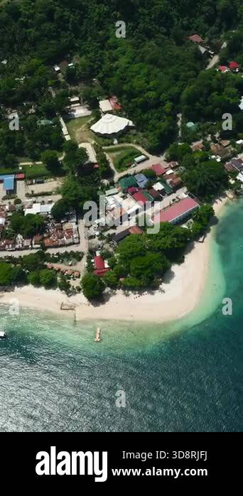 Coastline with houses and sandy white beach. Turquoise sea water with ...
