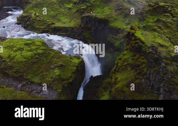 Aerial view shows a river cutting a basalt gorge, dropping into a mist ...
