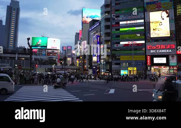 Street level view at Shibuya Scramble in Tokyo shows pedestrians, cars ...