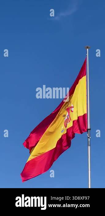 Spanish national flag gracefully moving in bright sunlight, symbolizing ...