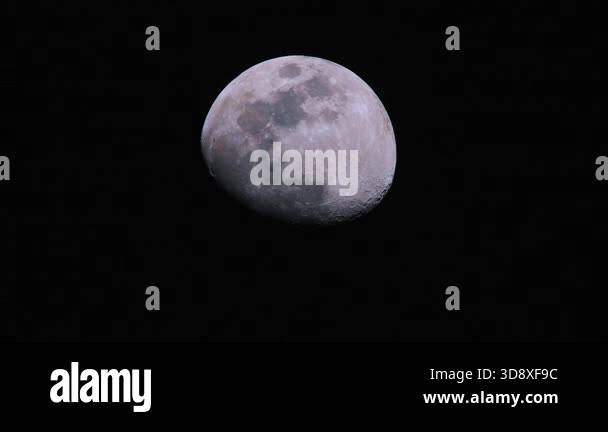 Luminous gibbous moon glowing brightly against deep dark sky, revealing ...