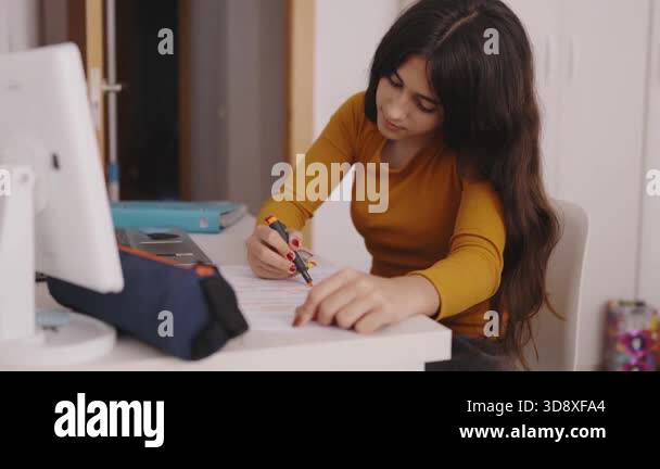 Teenage student writing homework while sitting at desk, concentrating ...