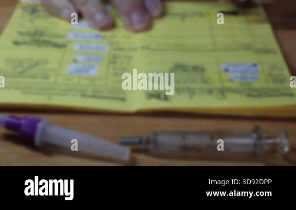 Doctor records the current vaccinations in the vaccination booklet in ...