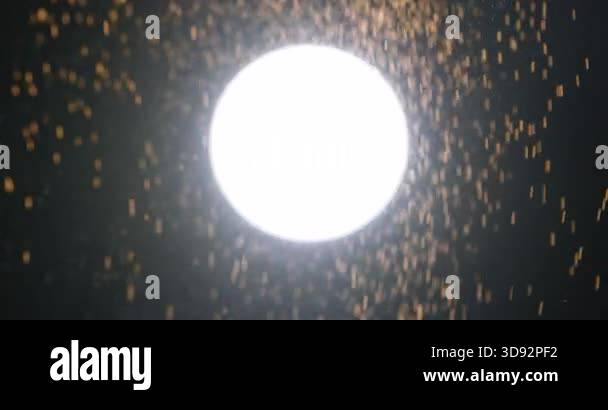 A luminous circle emits light while golden particles float gracefully ...