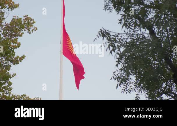 New flag of the Kyrgyz Republic flutters in the wind. National symbol ...
