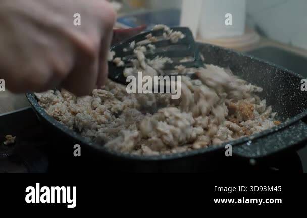 Frying ground meat in a skillet. Meat is stirred for even cooking ...