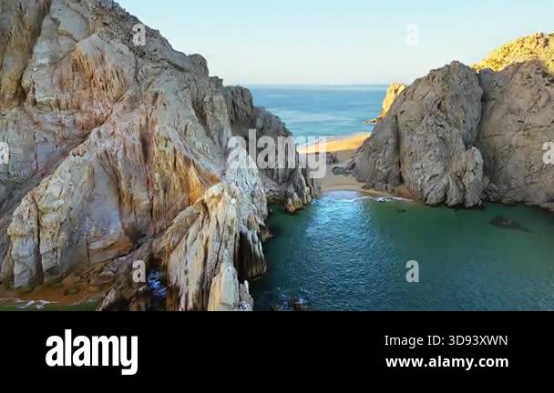 Aerial drone view revealing a secluded sandy cove nestled between ...