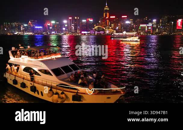 Boat cruising with city lights in background Stock Video Footage - Alamy