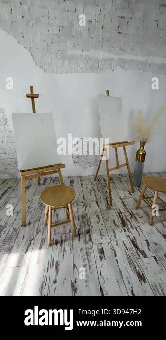 This bright art studio features a large table, a comfy chair, and ...