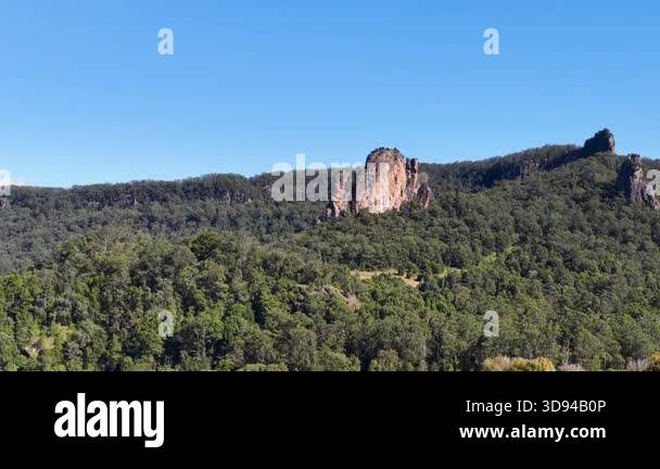 Panoramic view of Nimbin Rocks under clear blue skies. Lush greenery ...