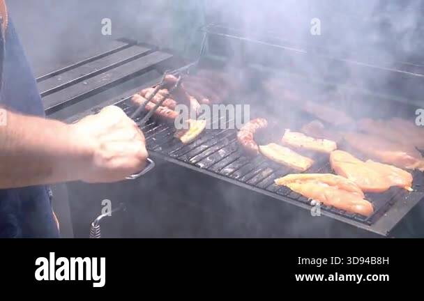 Man grilling meat on an outdoor barbecue. Leisure time with friends ...