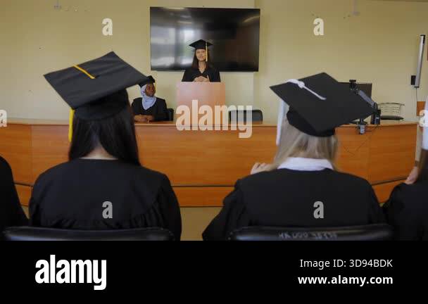 A young woman stands at the lectern and delivers a graduation speech to ...