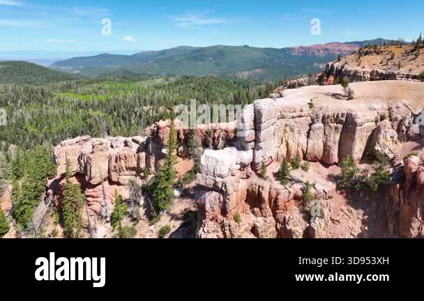 Majestic aerial fly through over rocky cliffs and lush pine forests in ...