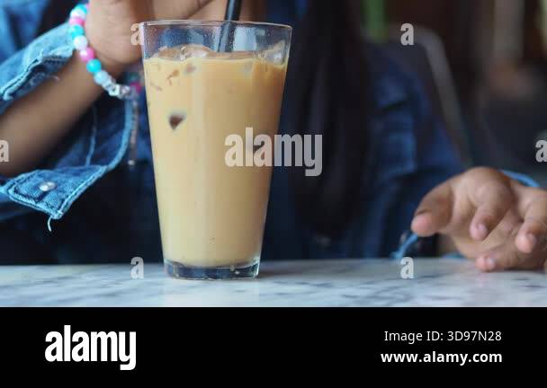 little girl Enjoying iced coffee in a cozy cafe setting Stock Video ...