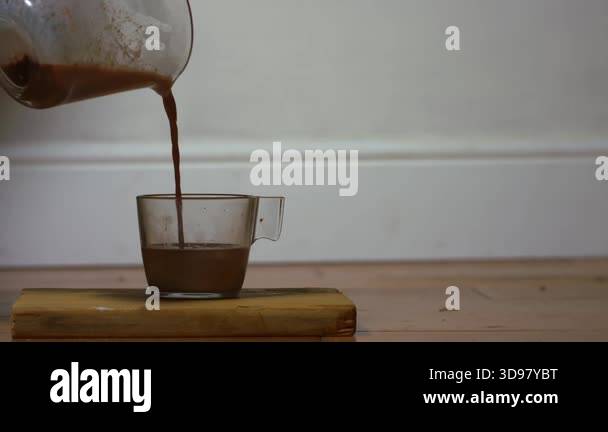 Pouring hot chocolate drink into mug wide zoom shot slow motion ...