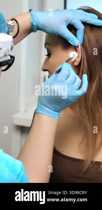 Close up of an ENT doctor cleaning and examining the ear canal of a ...