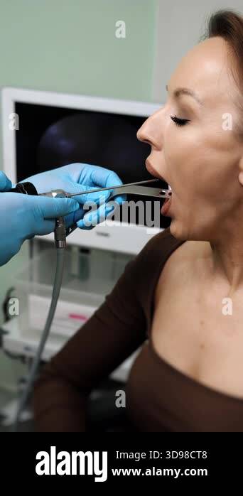 Close up of an ENT doctor performing a throat endoscopy examination on ...