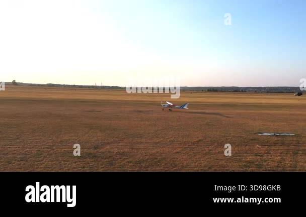 Small airplane takes off from grass airstrip of small airport ...
