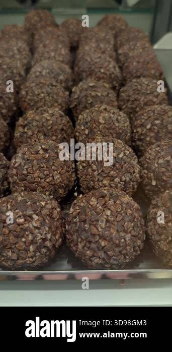 Brazilian fudge ball topped with chopped cocoa nibs in a bakery display ...