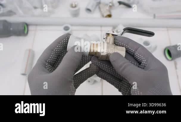 Plumber fits polypropylene coupling onto brass valve thread. Male ...