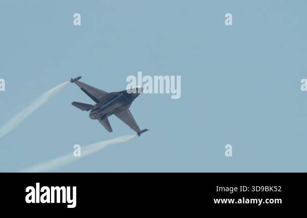 Jet fighter banking through the sky with vapor trails from wingtips ...