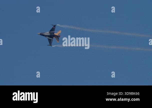 Decorative fighter jet performs acrobatic flight releasing vapor trails ...