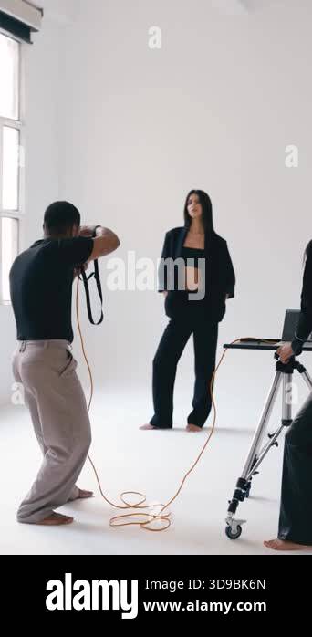 Photographer taking photos of a model posing in a professional studio ...