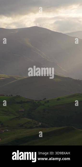 Stunning aerial view of a wind farm on top of a green mountain ...