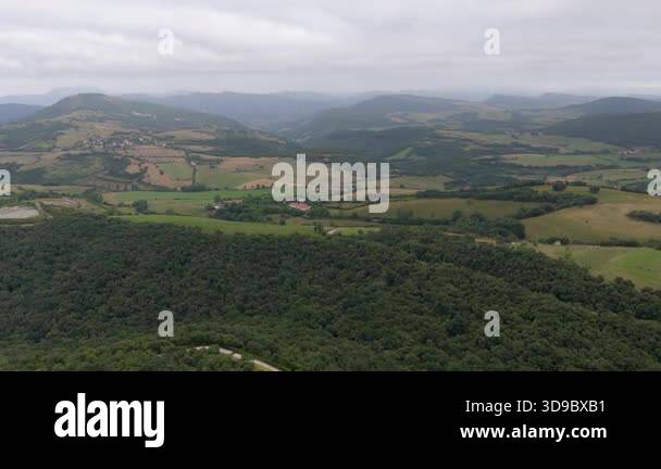 Expansive aerial view slowly moving over a vast green valley in aveyron, france. Lush forests ...