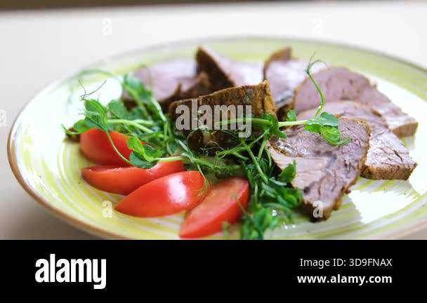 Woman slices ham bacon meat thick pieces on a wooden board, beef or ...