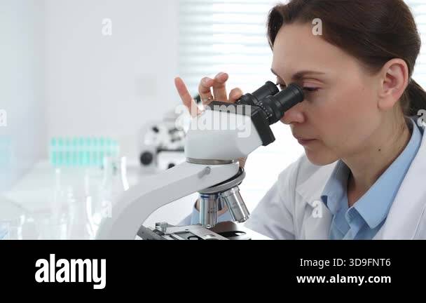 Female scientist analyzing microscope samples, researching ...