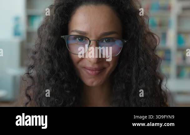 Hispanic Arab happy woman glasses touching hair student library ...