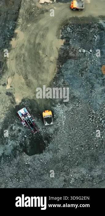 aerial top view excavator and truck operating in muddy pit, tire tracks ...