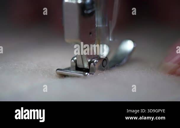Close macro view shows the sewing machine foot gliding across dense ...